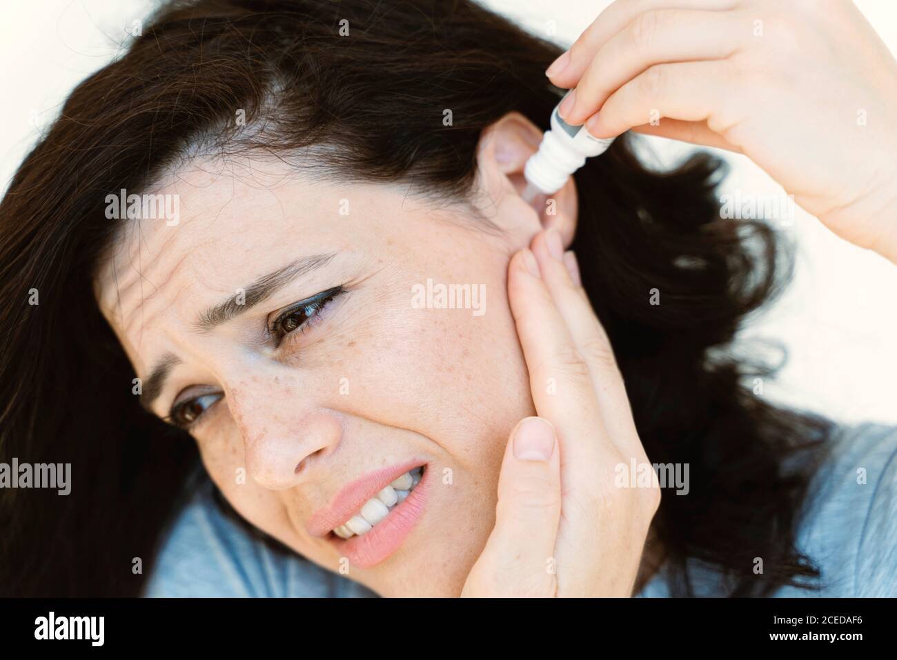 Closeup female hand is holding white little bottle with healing drops ...