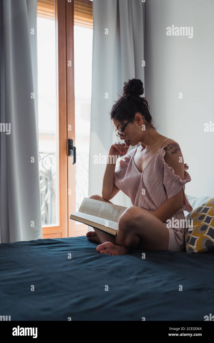 Woman with book chilling on bed Stock Photo - Alamy