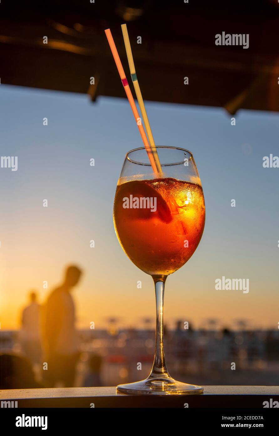 A glass of aperol cocktail stands against the sunset sky Stock Photo ...