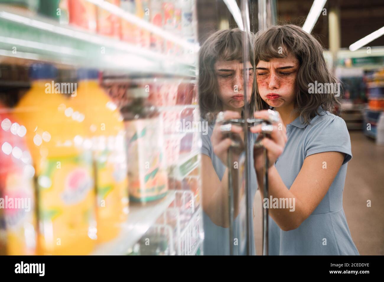 Young Woman with gray hair puffing cheeks and keeping eyes closed while ...