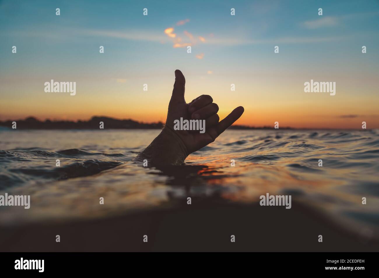 Closeup hand of human showing shaka sign above water surface with ...