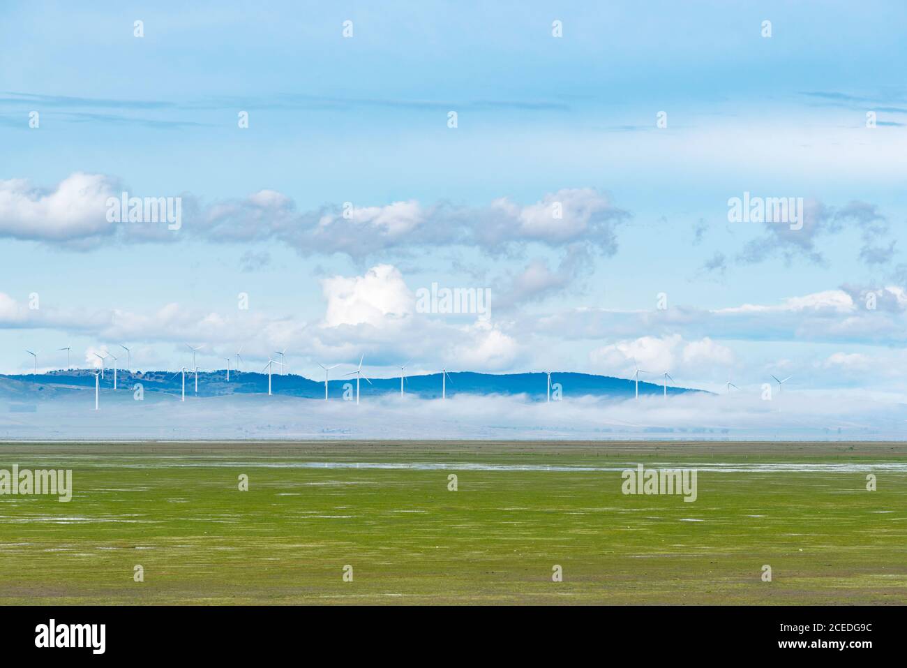 Low clouds and wind turbines reflect in the recently refilled Lake ...