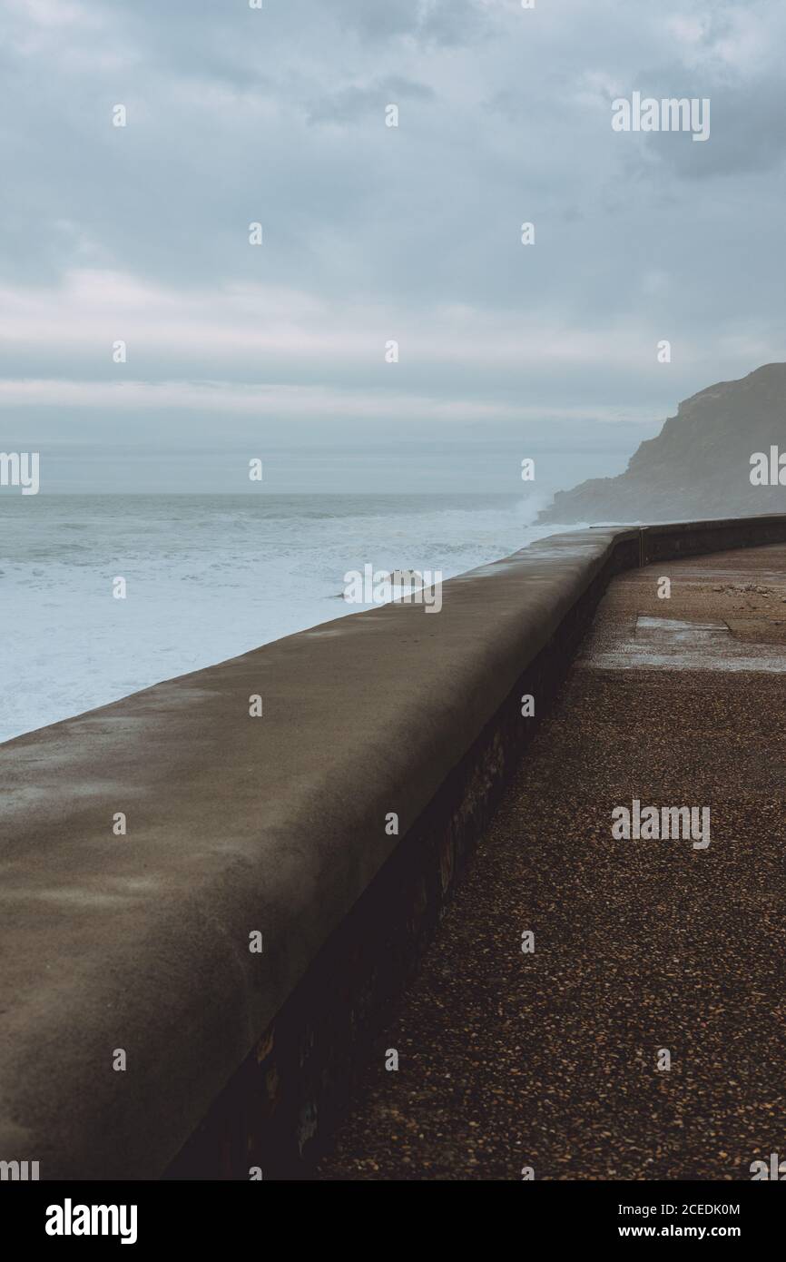 Perspective view paved seafront foamy stormy waves ocean background hi ...