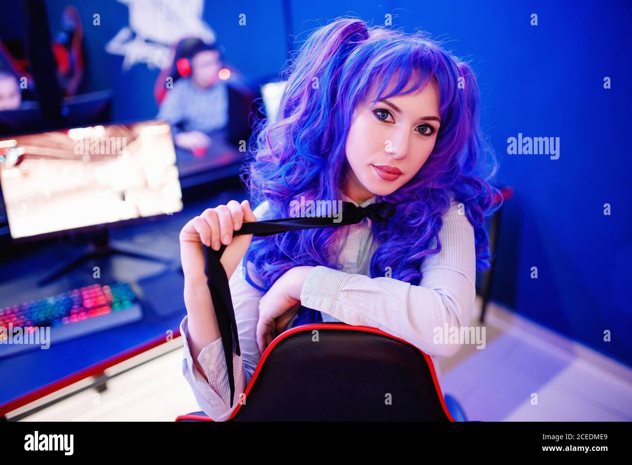 Woman gamer sitting table, playing online games on computer, neon color ...