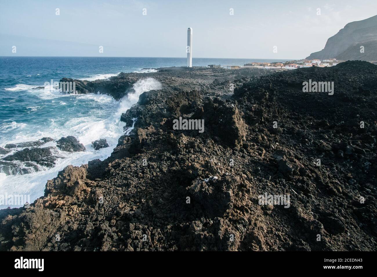 Picturesque view of gray rocky cliffs with tower of lighthouse on ...