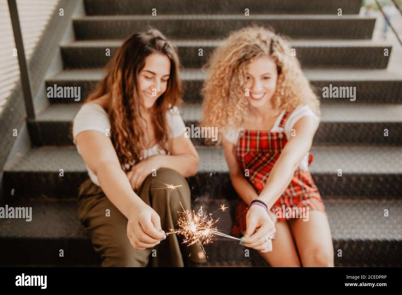 Friends with sparkles on steps Stock Photo - Alamy