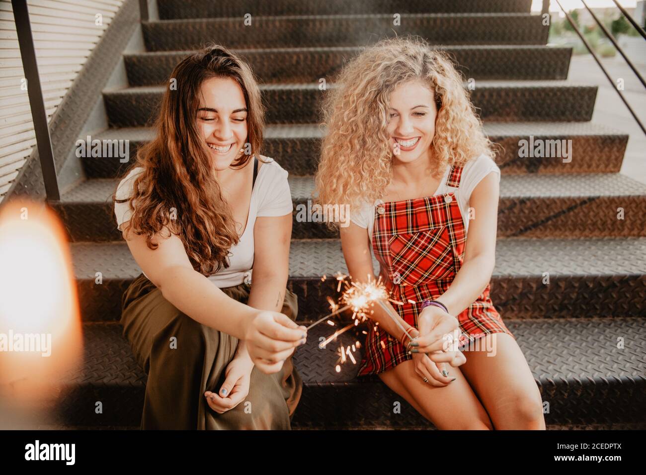 Friends with sparkles on steps Stock Photo - Alamy