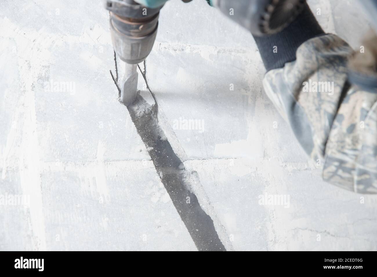 Builder worker man using jackhammer to drill into construction wall for ...