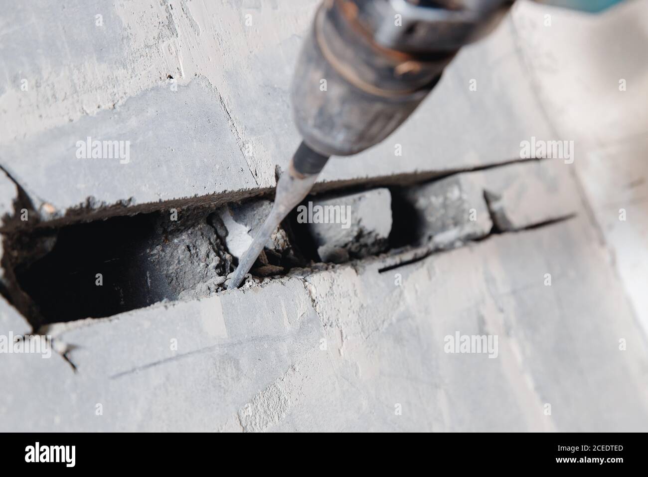 Builder worker man using jackhammer to drill into construction wall for ...