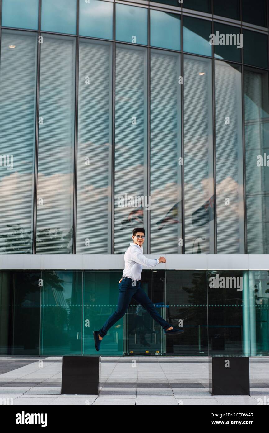 man jumping on pavement of highrise Stock Photo - Alamy
