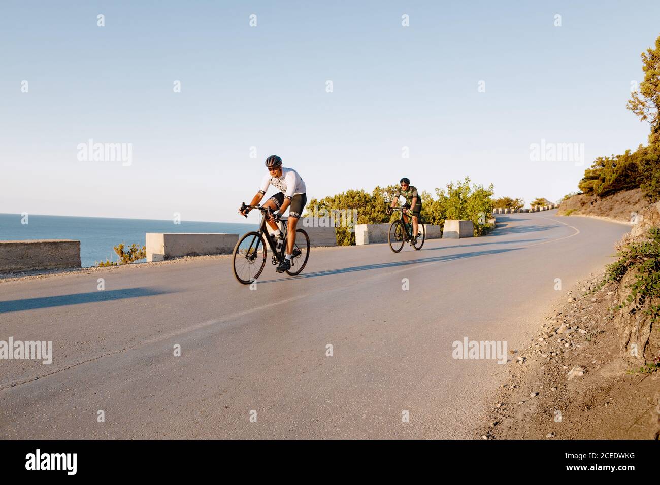 Two professional male cyclists riding their racing bicycles in the ...
