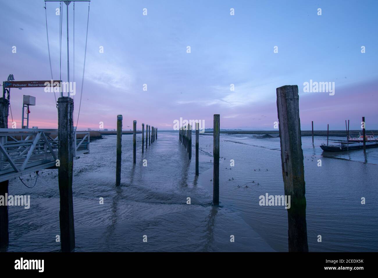 Row of wooden posts in the sea during twilight Stock Photo - Alamy