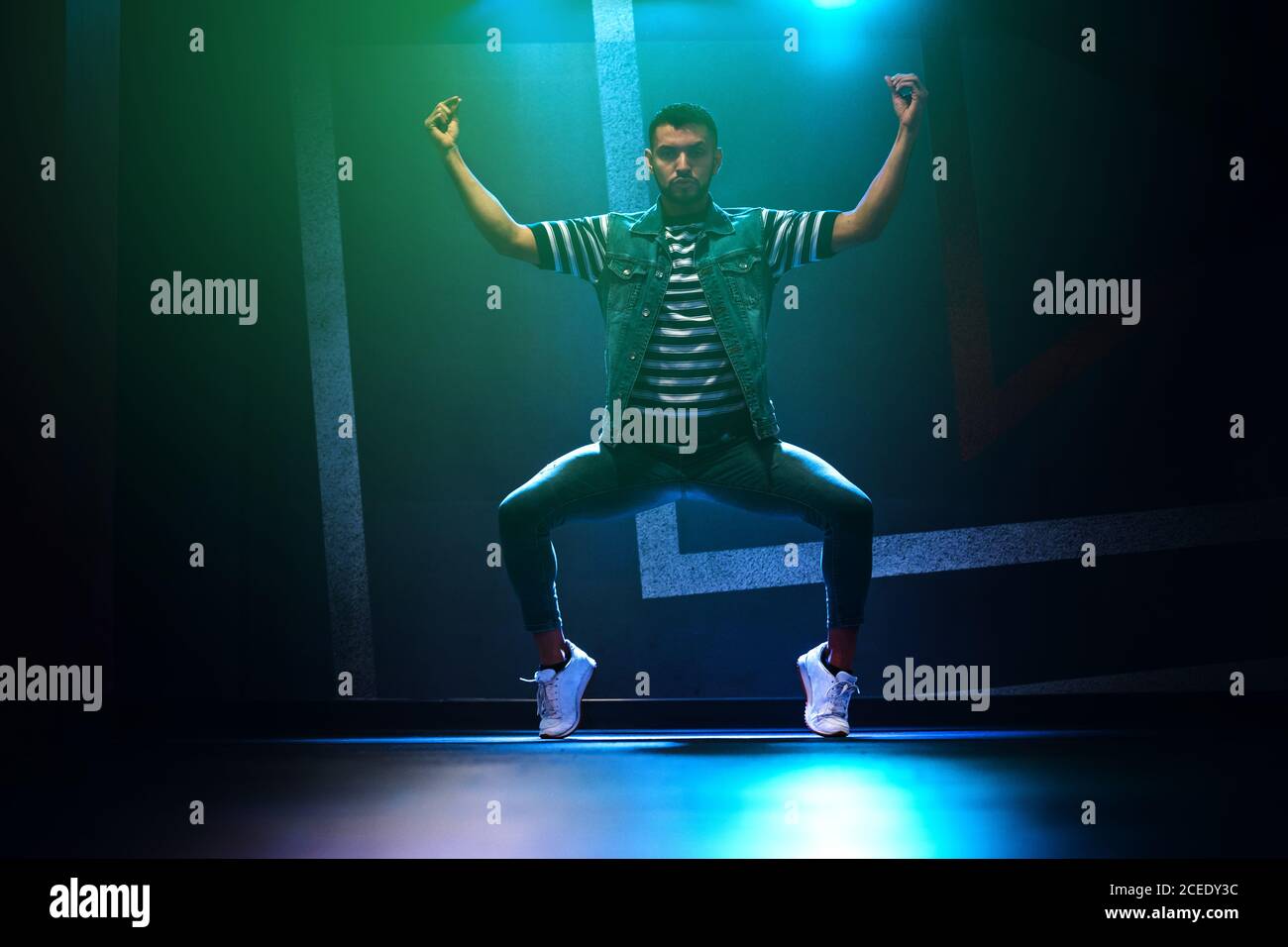 Handsome bearded man dancing in spotlight Stock Photo - Alamy