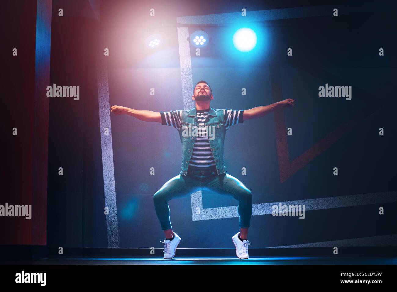 Handsome bearded man dancing in spotlight Stock Photo - Alamy