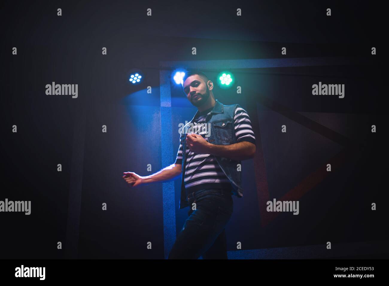 Handsome bearded man dancing in spotlight Stock Photo - Alamy