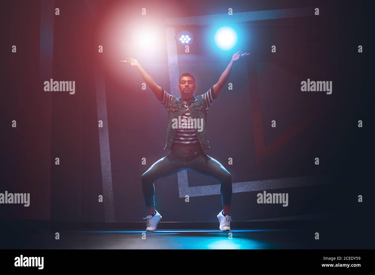 Handsome bearded man dancing in spotlight Stock Photo - Alamy