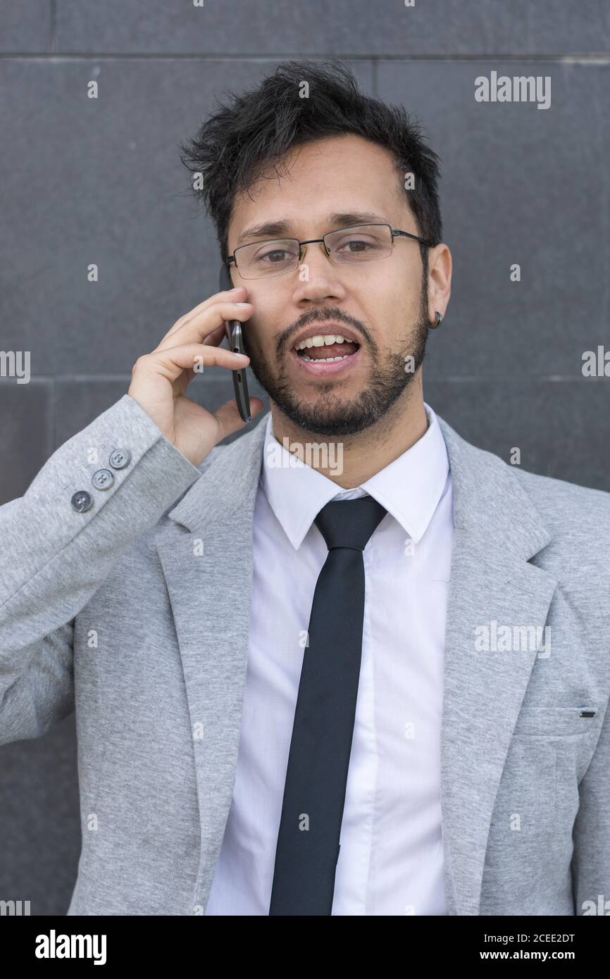 Portrait of latin businessman, on a wall of the building where he works ...