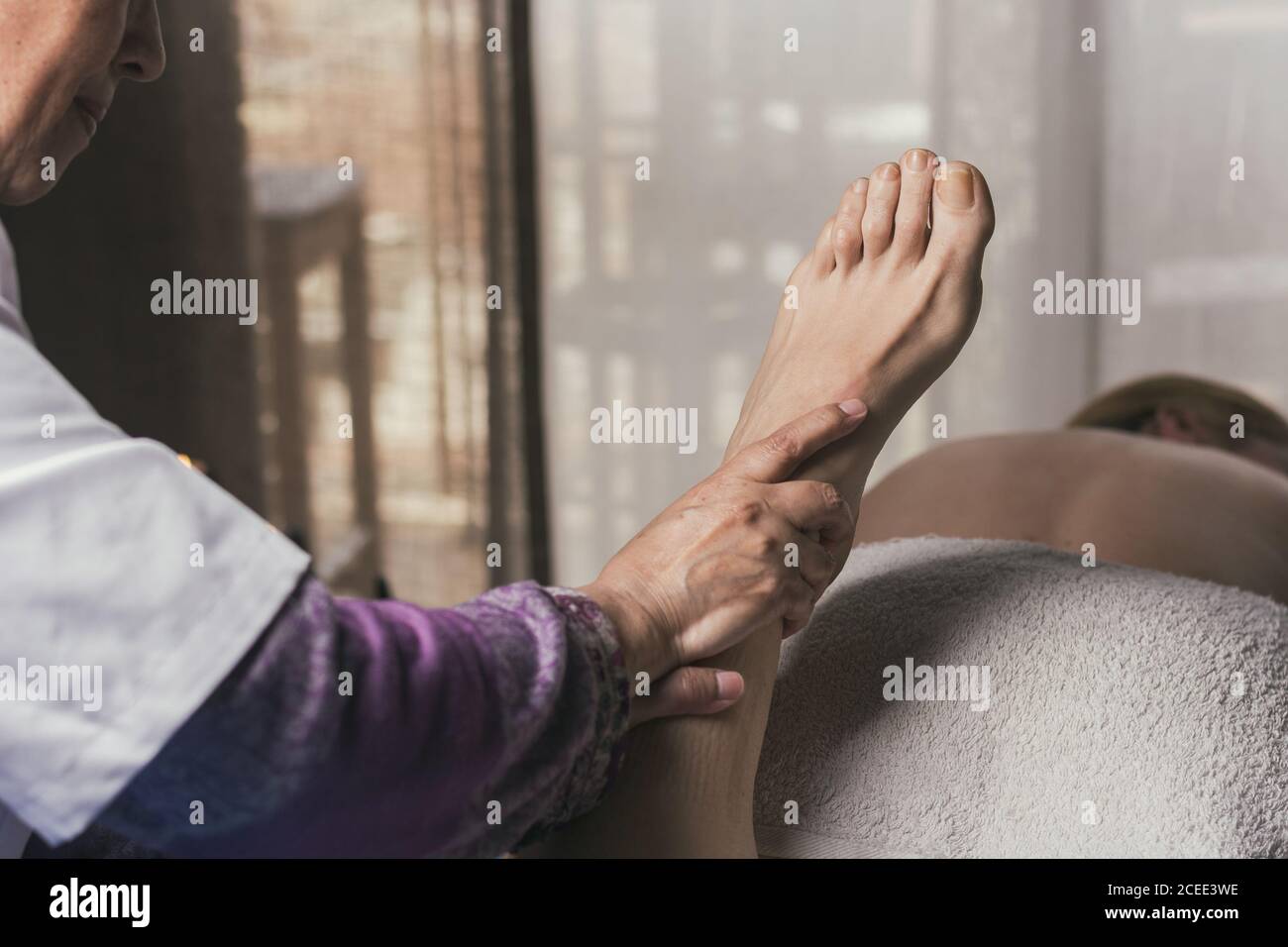 Therapist doing foot reflexology massage on patient. Treatment to ...