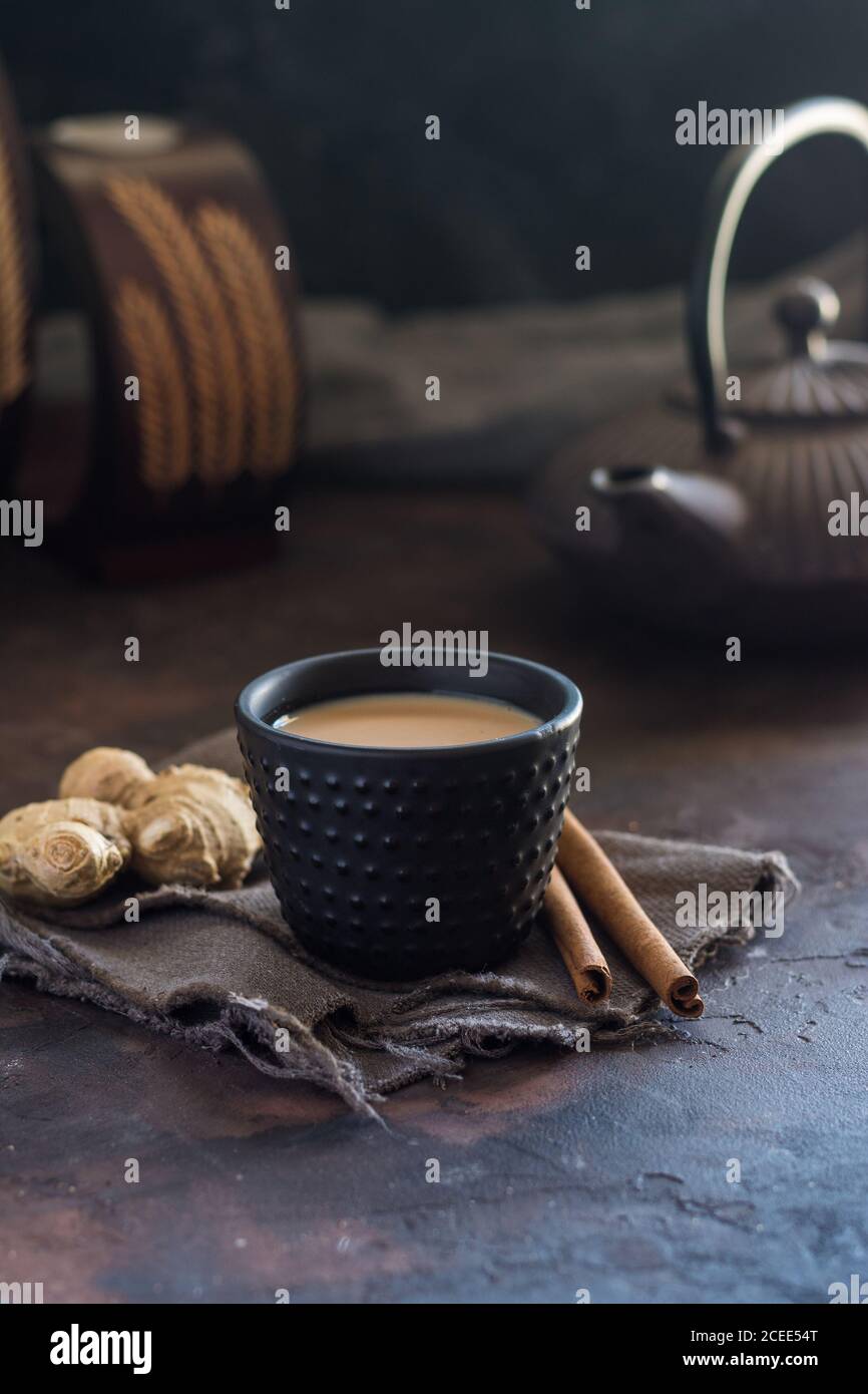 Oriental cup of tea Chai, Its ingredients with milk, cinnamon, ginger ...