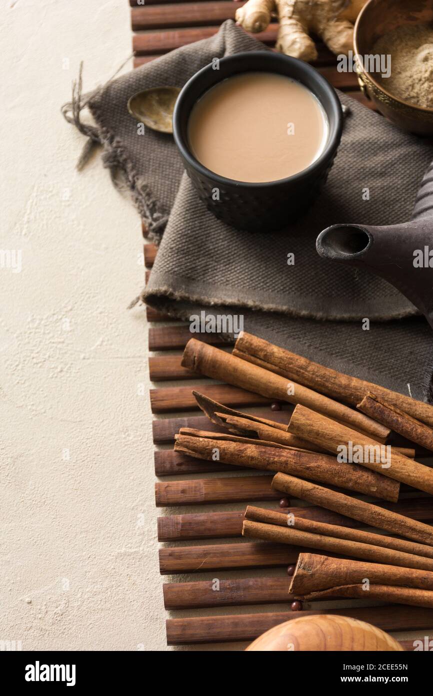 Oriental cup of tea Chai, Its ingredients with milk, cinnamon, ginger ...