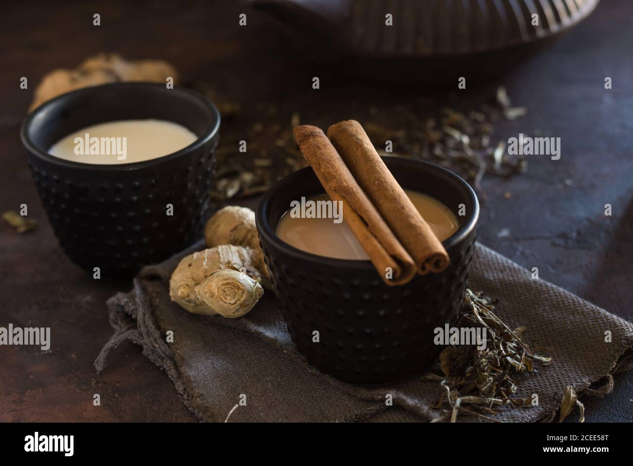 Oriental cup of tea Chai, Its ingredients with milk, cinnamon, ginger ...