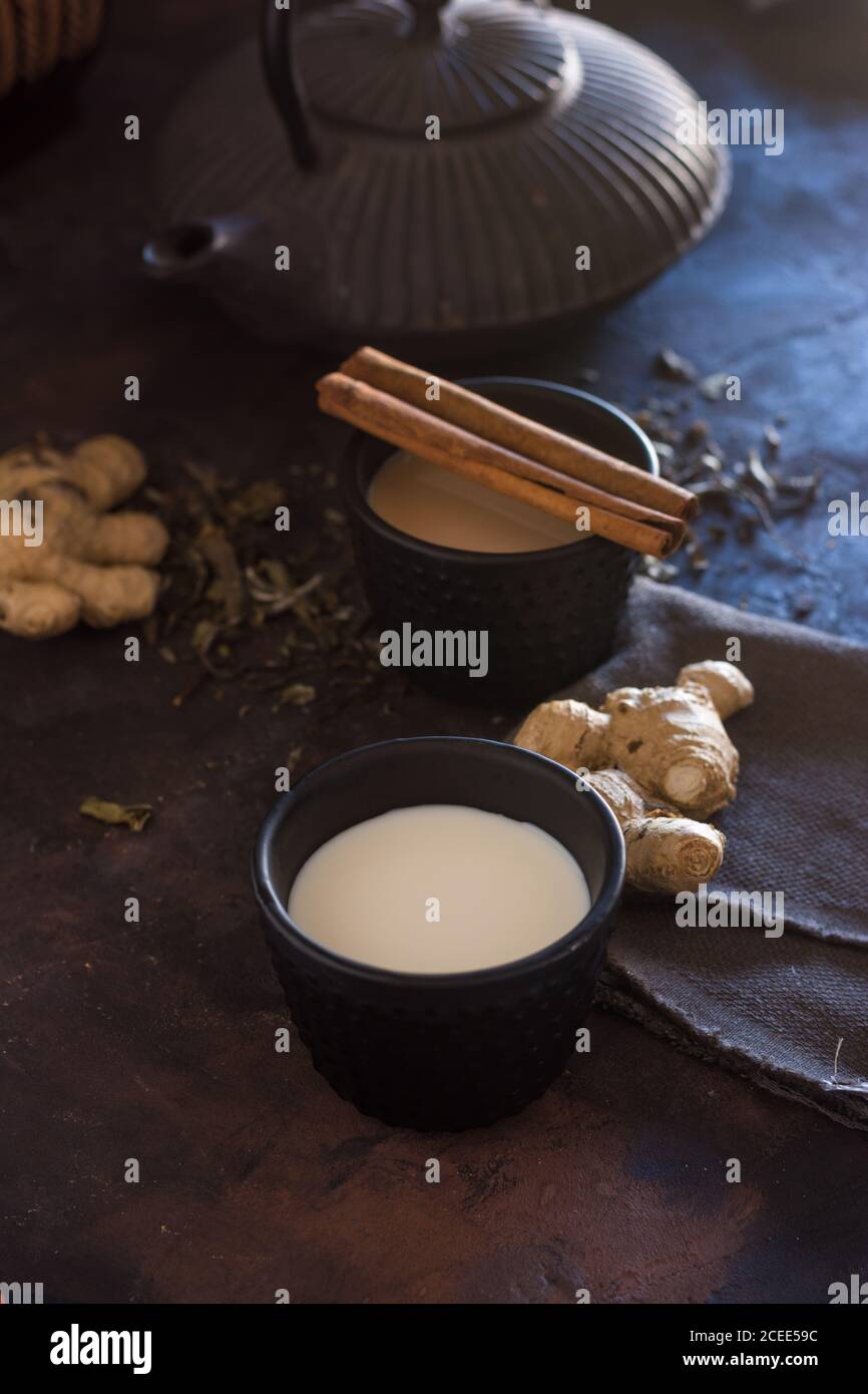 Oriental cup of tea Chai, Its ingredients with milk, cinnamon, ginger ...