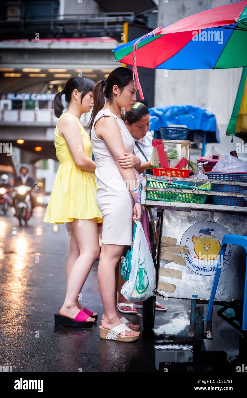 Thai Girls Out For Lunch Wait For Their Food Order At A Noodle Cart Vendor On Sukhumvit Rd