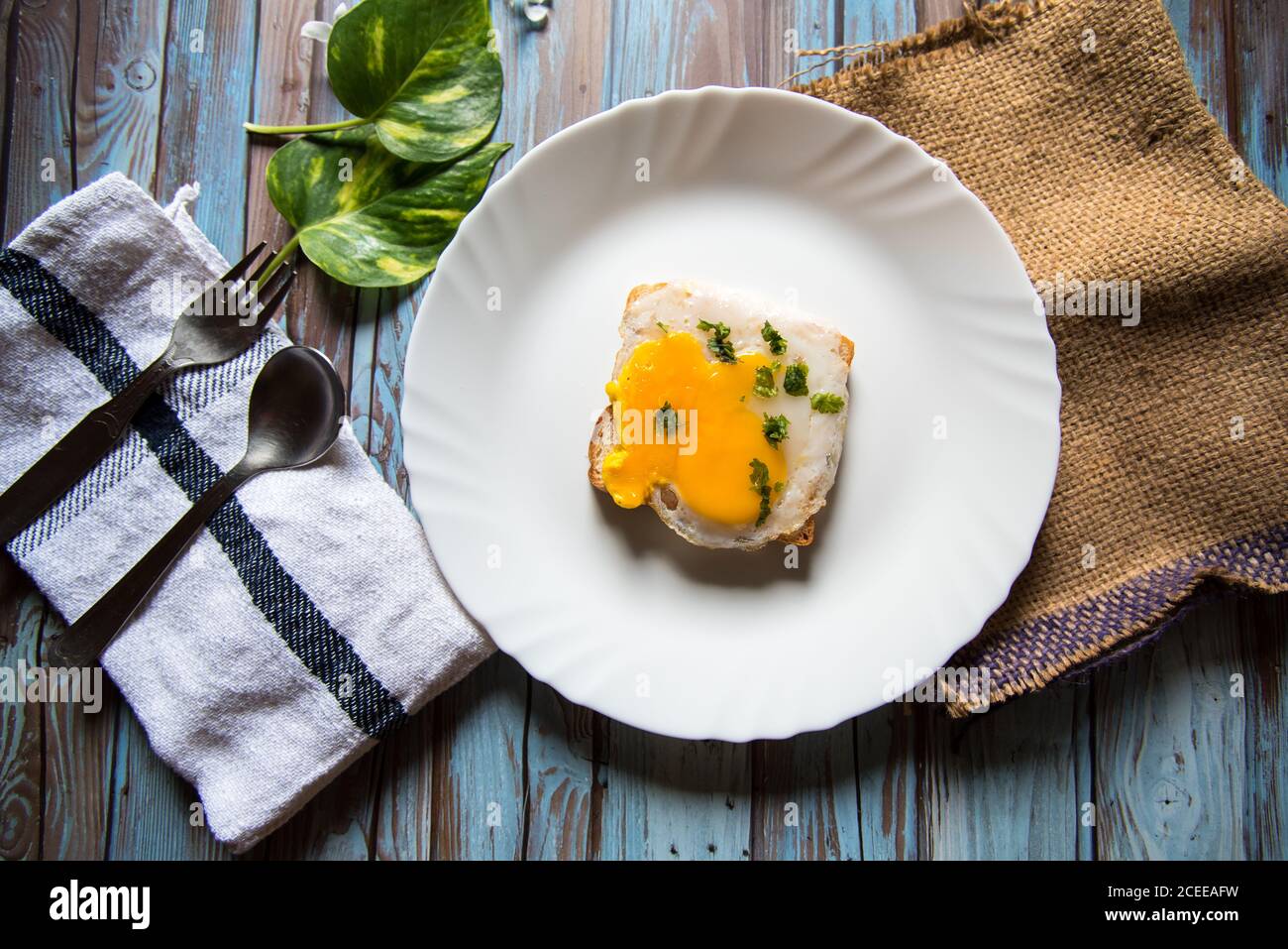 Eggs and bread with condiments as breakfast Stock Photo - Alamy