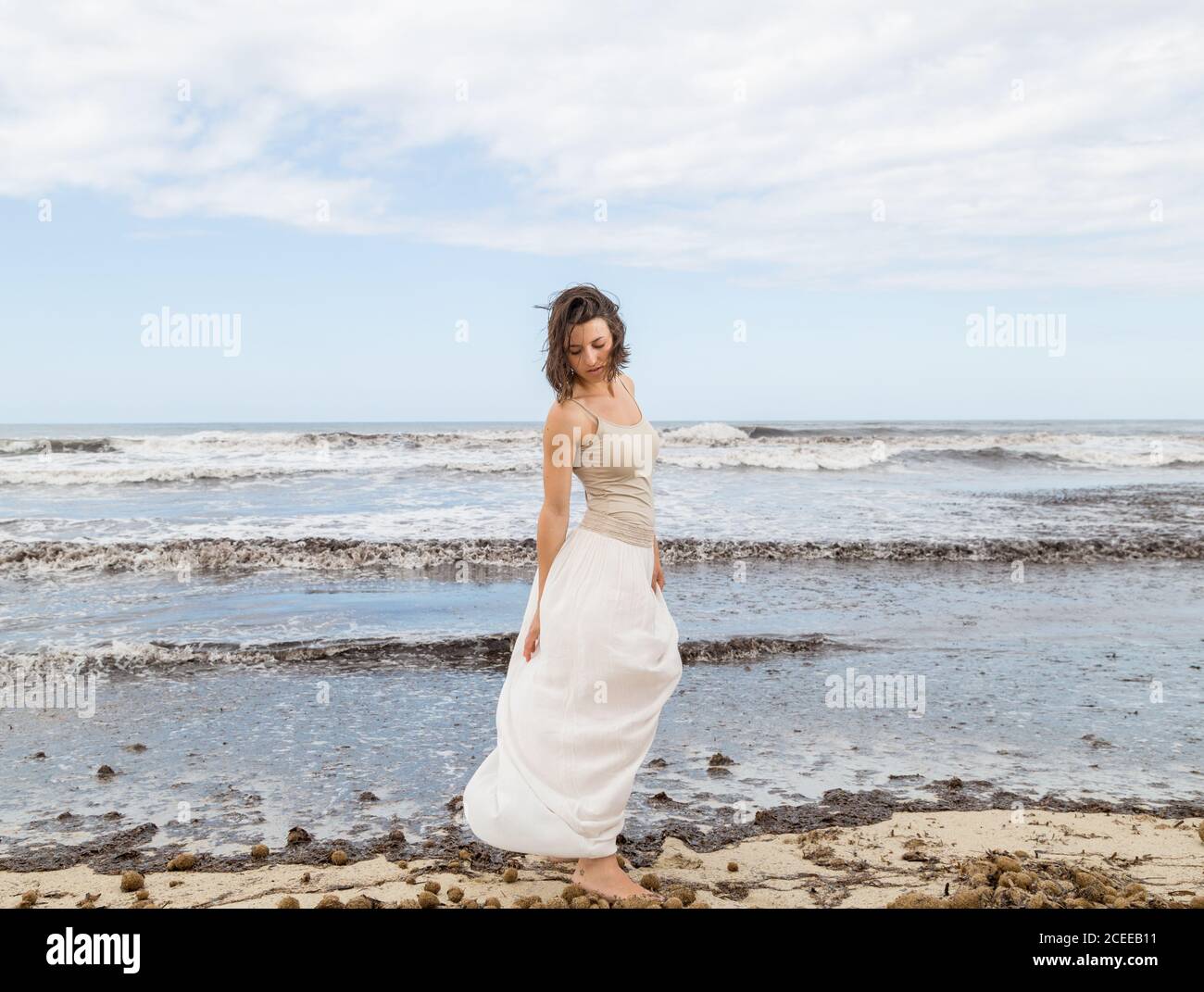 Side view of passionate attractive slim lady posing on beach near ...
