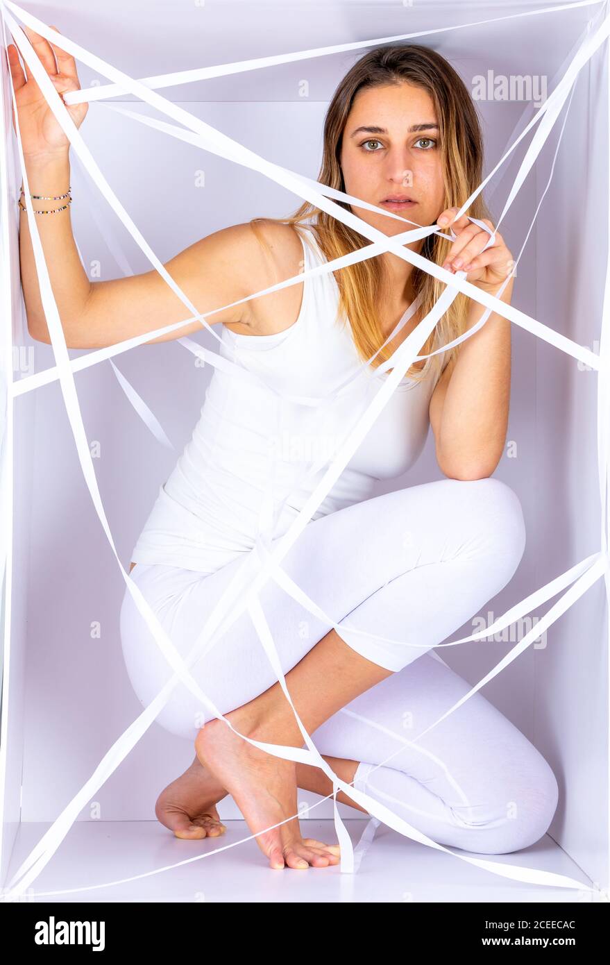 Young fit Woman wearing white outfit and posing inside of white box ...
