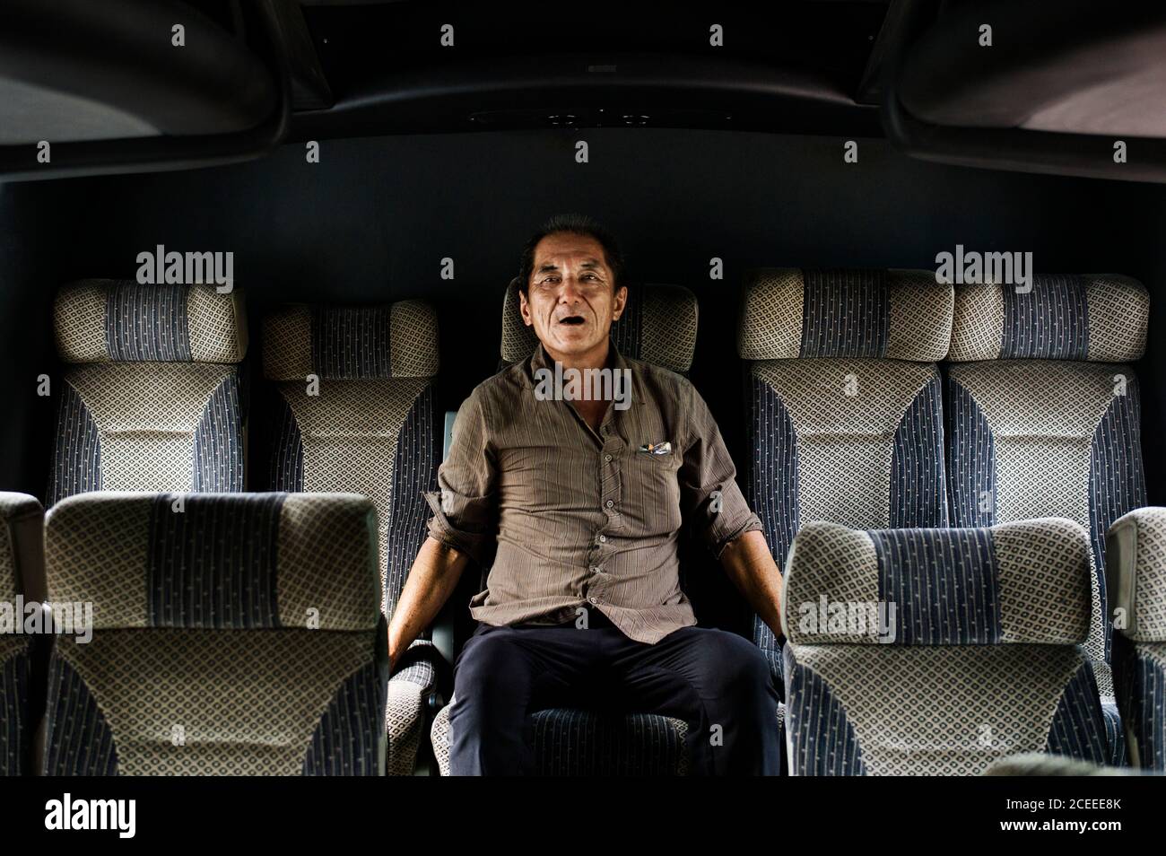 Senior man sitting on comfortable seat in bus with expression of ...