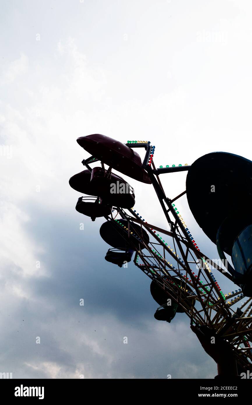 Silhouette of roundabout decorated with colorful lights from below ...