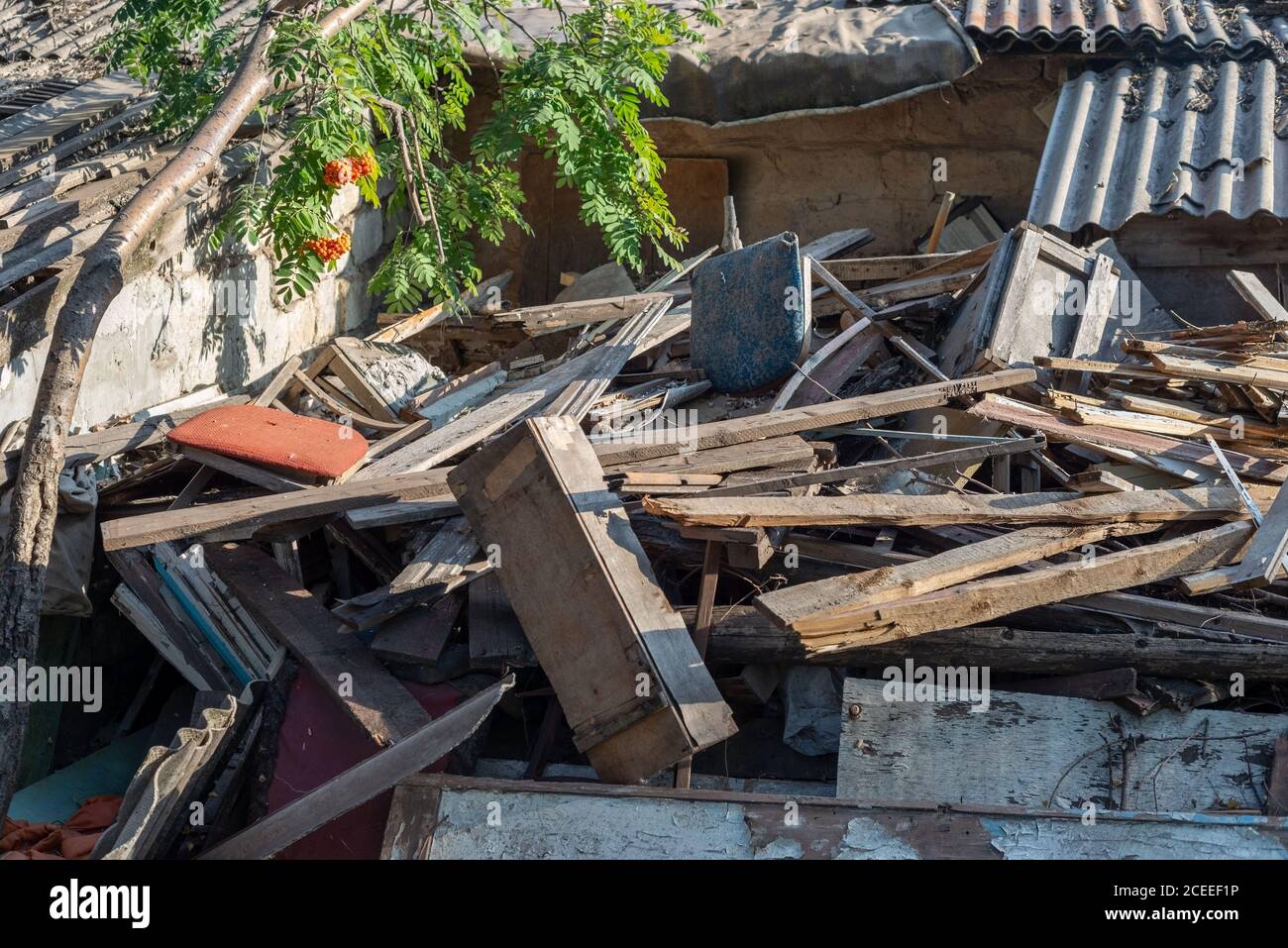 heap of rubbish with old boards, against the background of the old ...