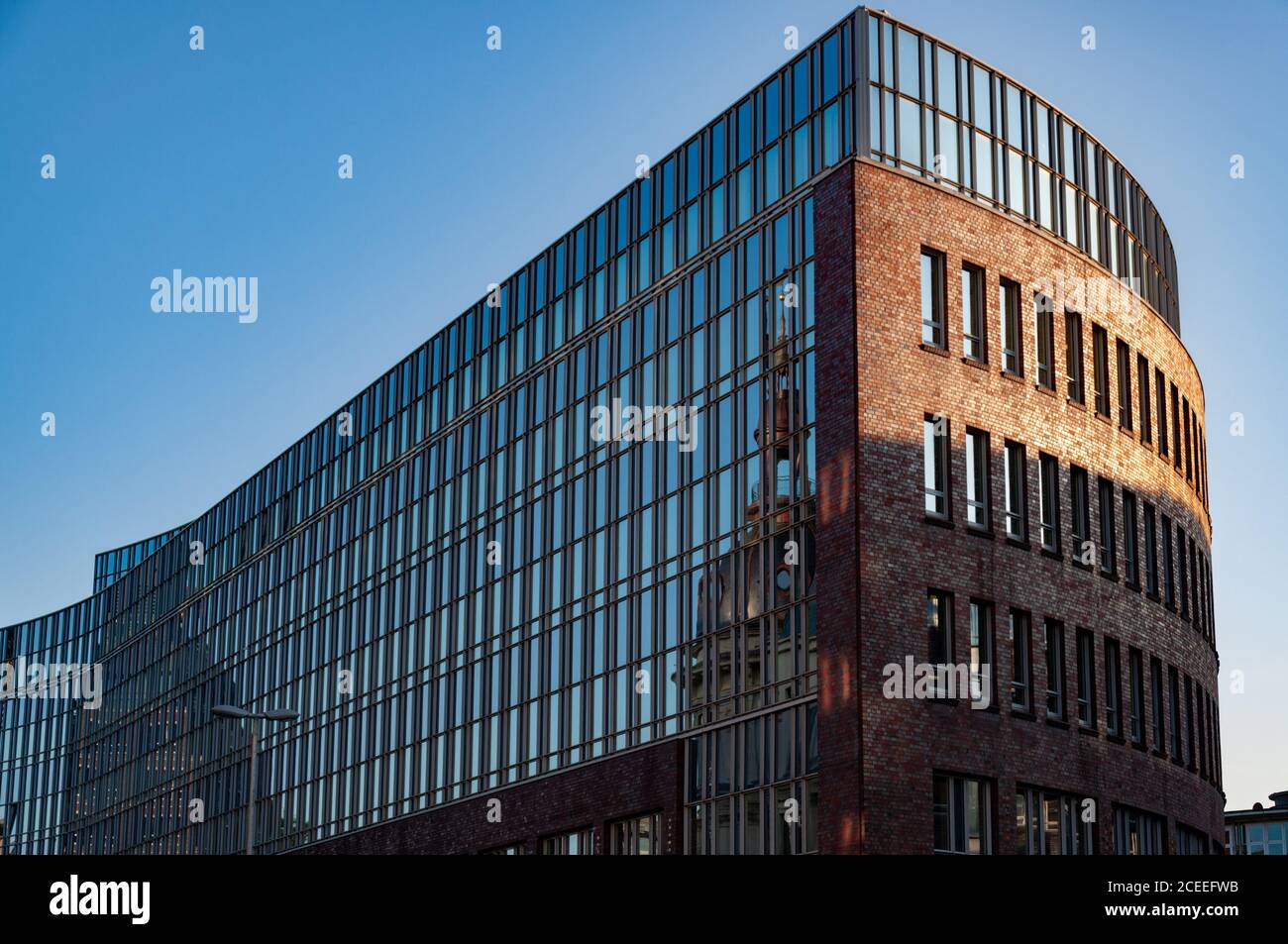 Golden sunset light to corner of skyscraper business center on blue sky ...