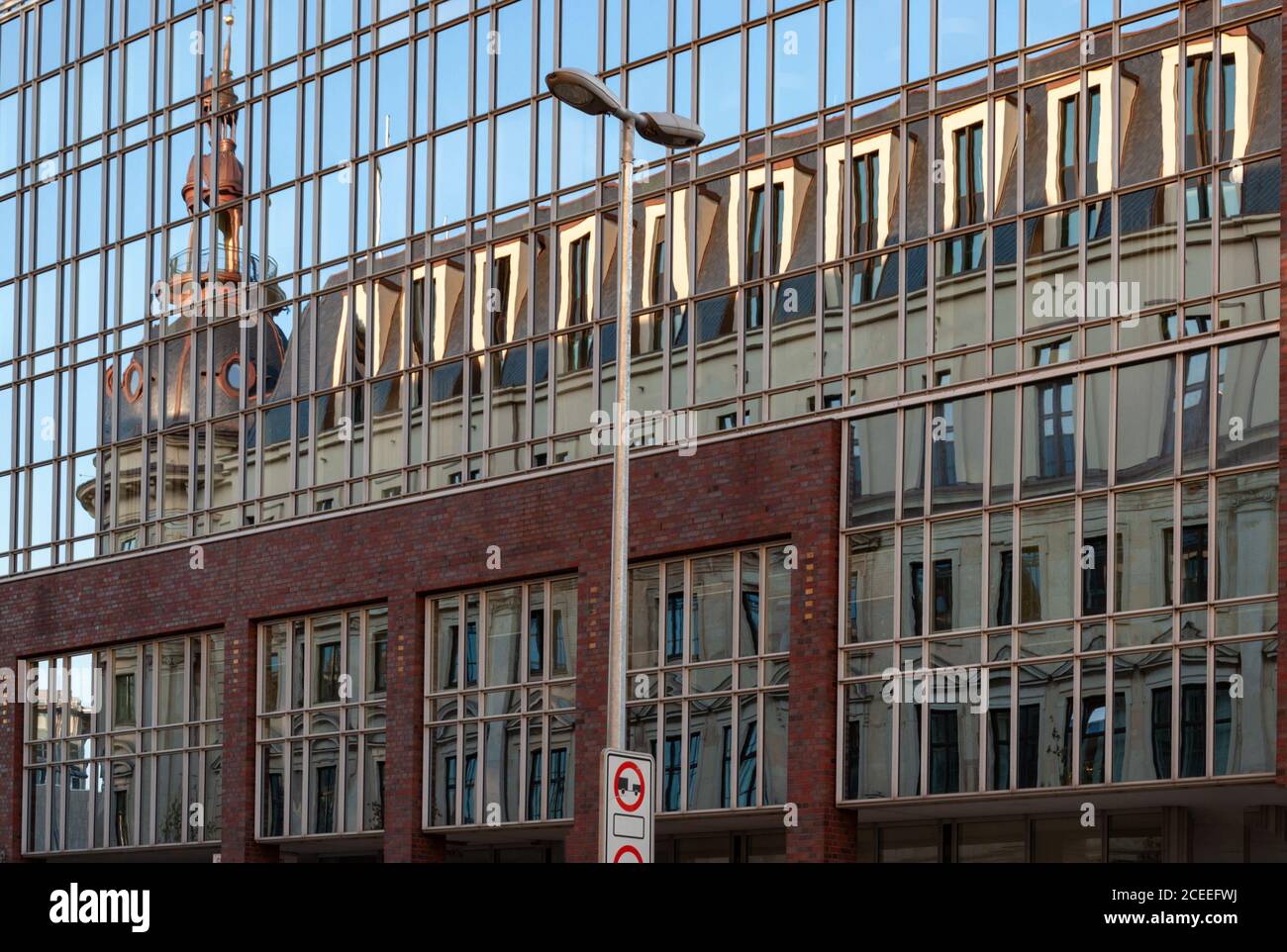 Distorted reflection of historic building with chapel tower in glass ...
