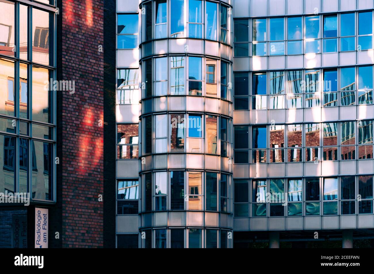 Corporate building exterior with distorted reflection in mirrored glass ...