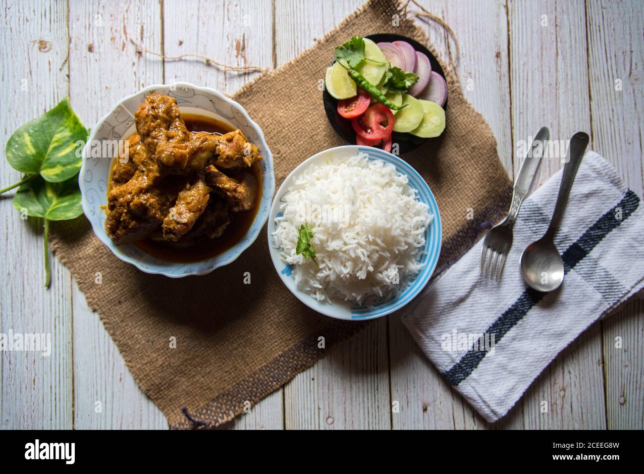 Top view of chicken curry, rice and salad ingredients, a popular Indian ...
