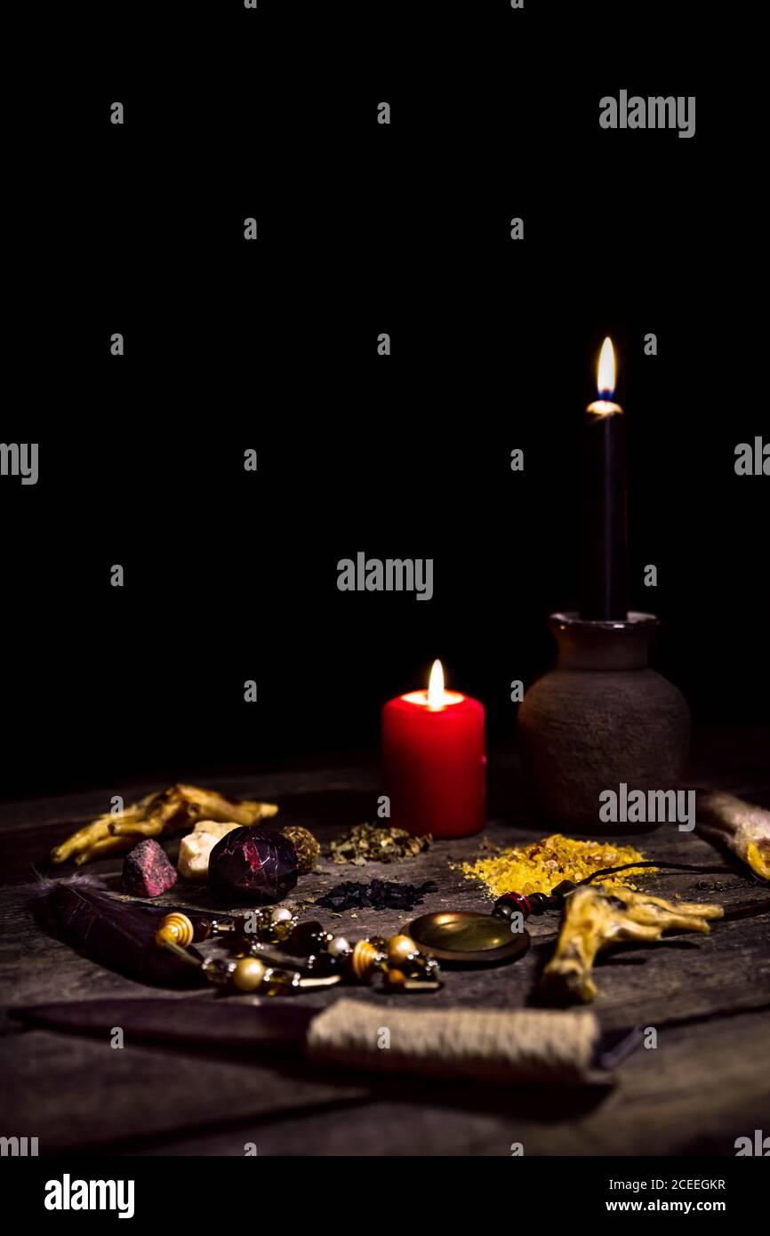 Dark vodun or voodoo ritual table in front of black background, magic ...