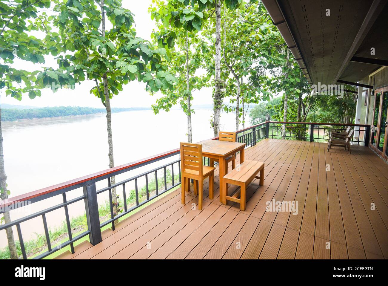 Wooden table and chairs on balcony and nature green tree forest ...
