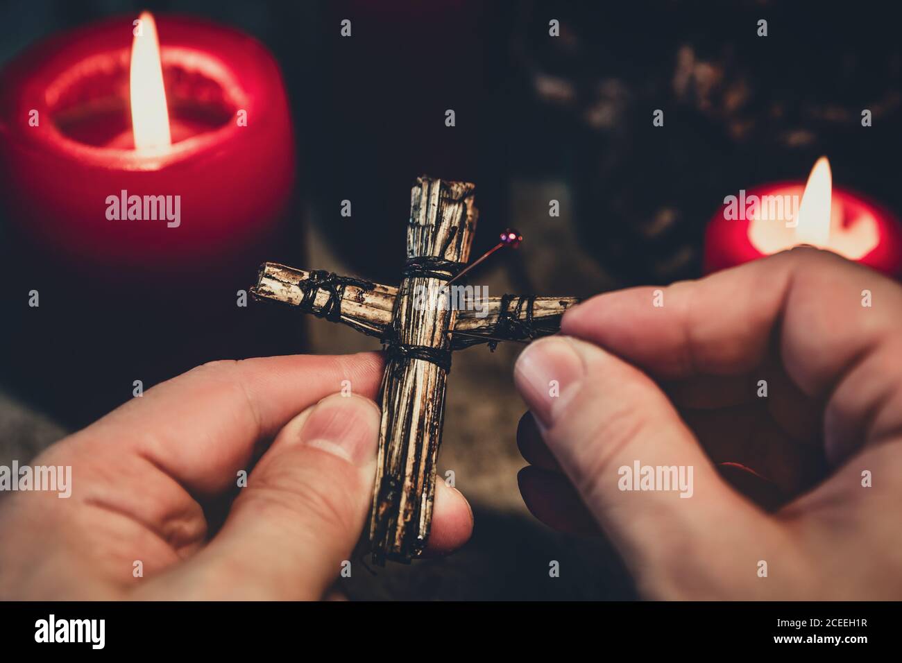 Man stitching needles in a voodoo or vodun puppet, dark witchcraft ...
