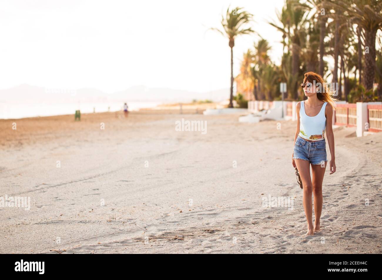 Slim Woman strolling on tropical beach Stock Photo - Alamy