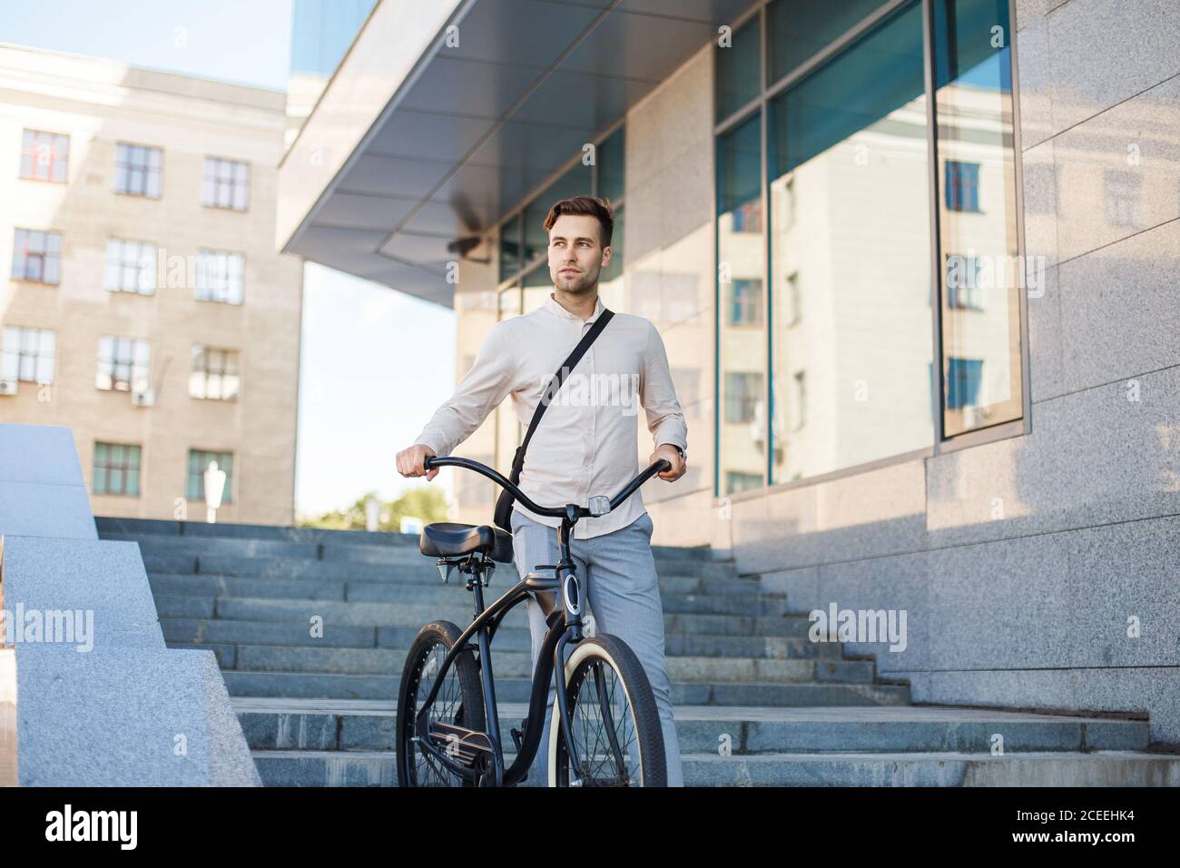 Healthy and active lifestyle. Young businessman walking with bicycle ...