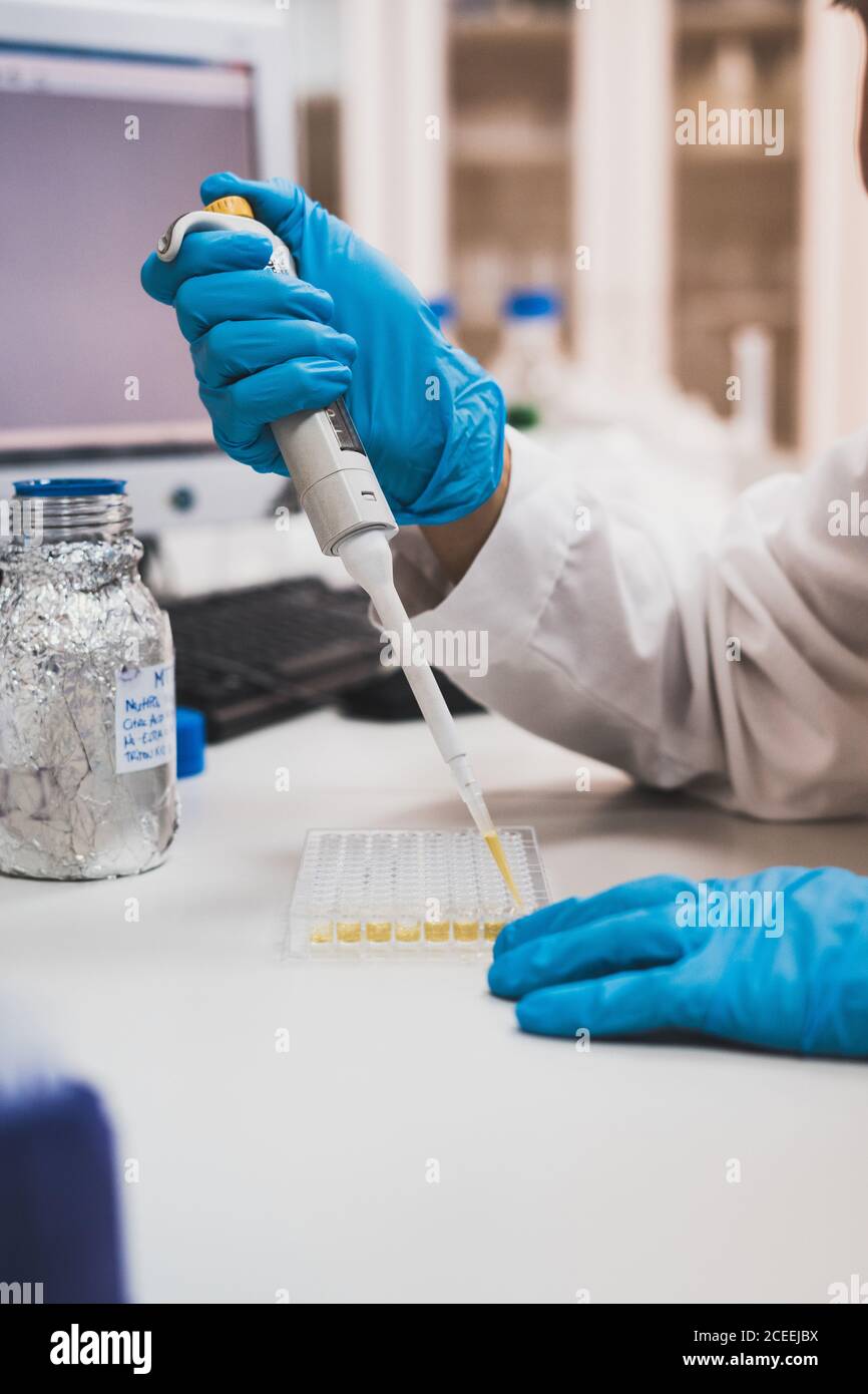 Crop view of hands of worker in rubber gloves and uniform using tool ...