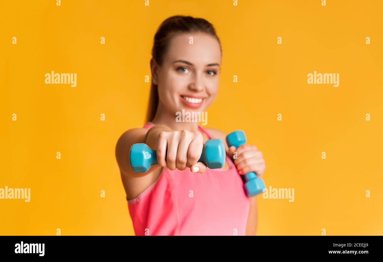 Sporty Girl Doing Dumbbell Boxing Workout Over Yellow Studio Background ...