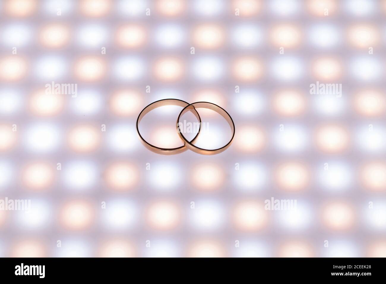 Wedding rings close-up, with LED lighting and dark background. View top ...