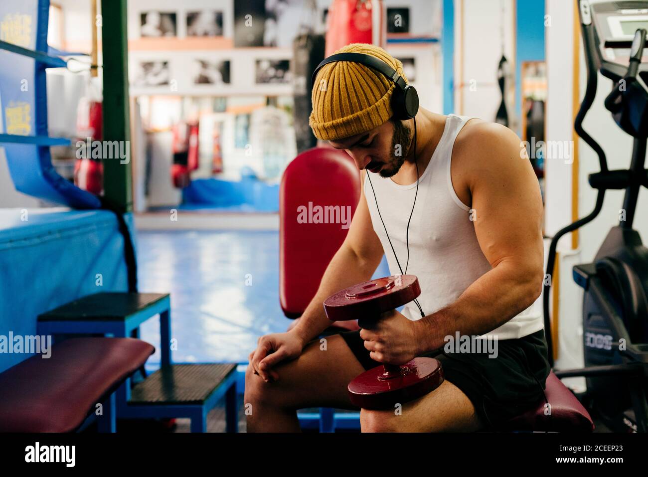 man in headphones listening to music and exercising with dumbbell in ...