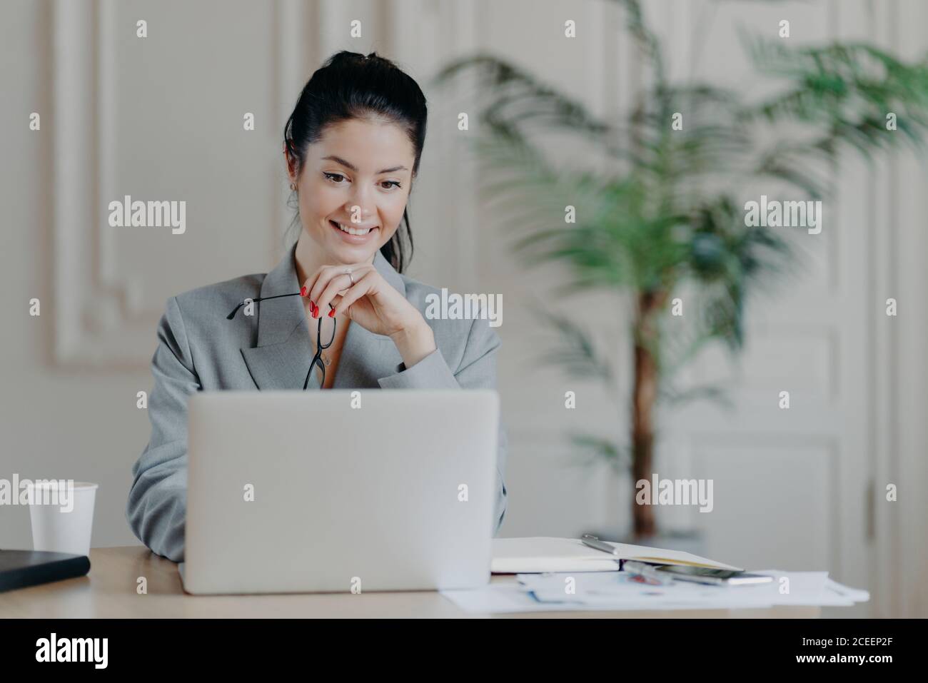 Cheerful young professional woman searches update notification for ...