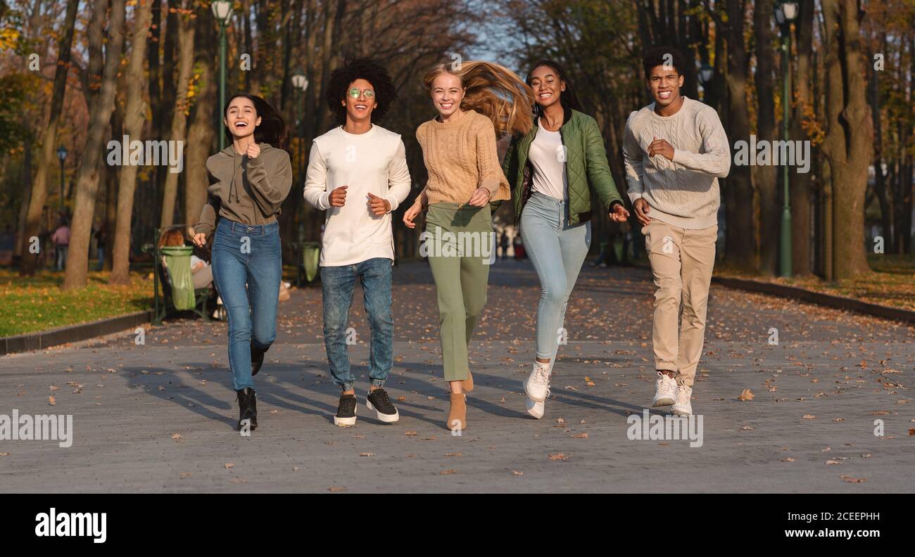 Crazy teens running towards camera, park background Stock Photo - Alamy