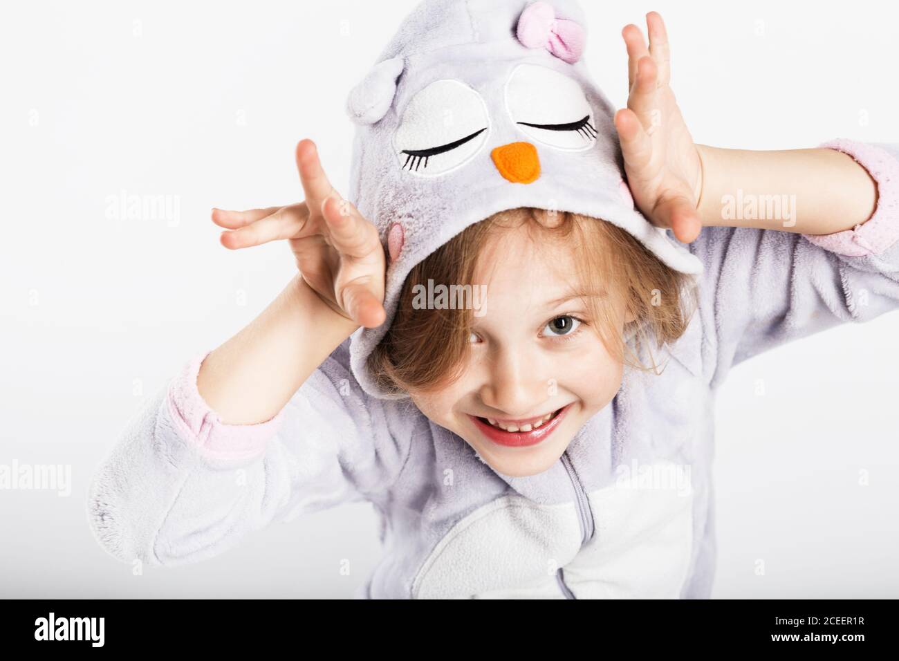 Funny little girl in pajamas jumping and having fun in bed at home ...