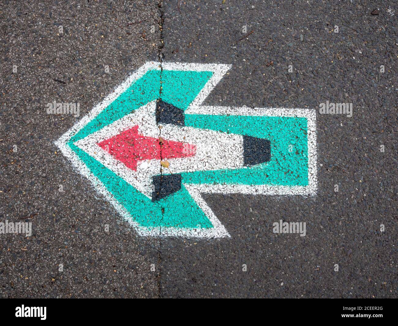 Colourful direction arrow drawn on the pavement Stock Photo - Alamy